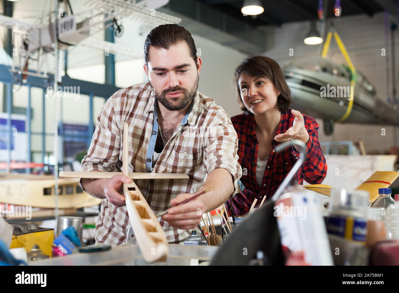 Positive couple enjoying their hobbies - modeling light airplanes in ...