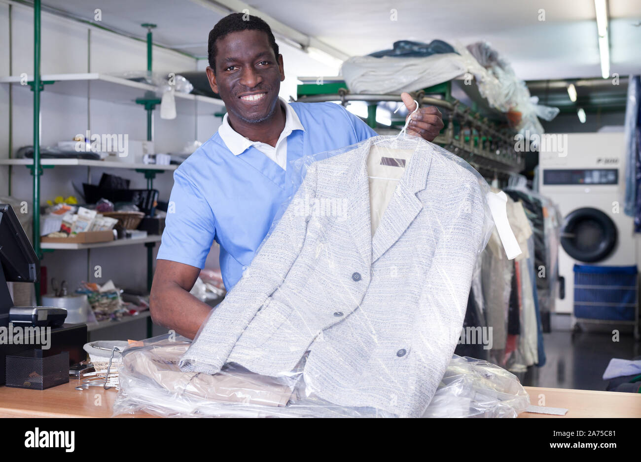 Happy African American worker of laundry offering professional dry ...