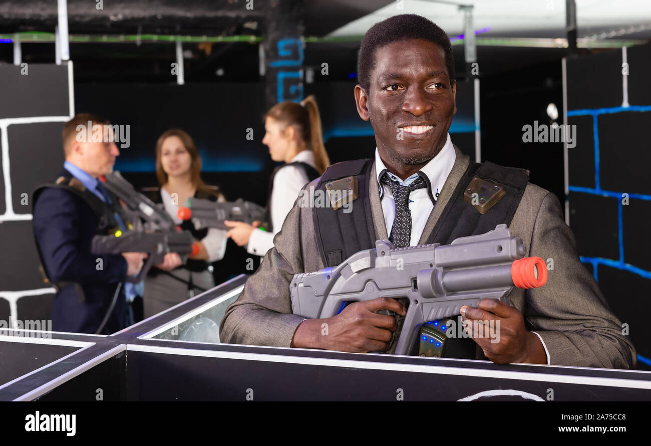African American man in a business suit holding laser gun and playing ...