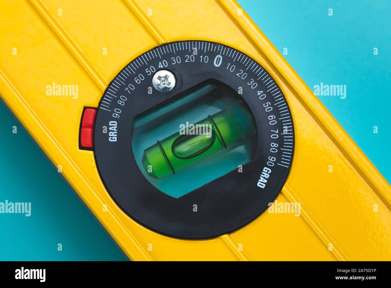 Yellow level tool on blue background. A tubular spirit level close-up ...