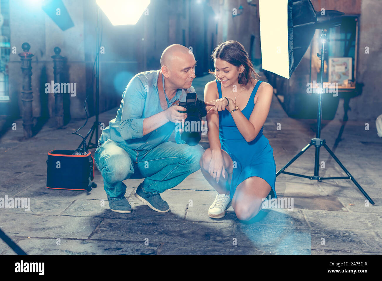 Professional photographer showing photos on a digital camera to smiling ...