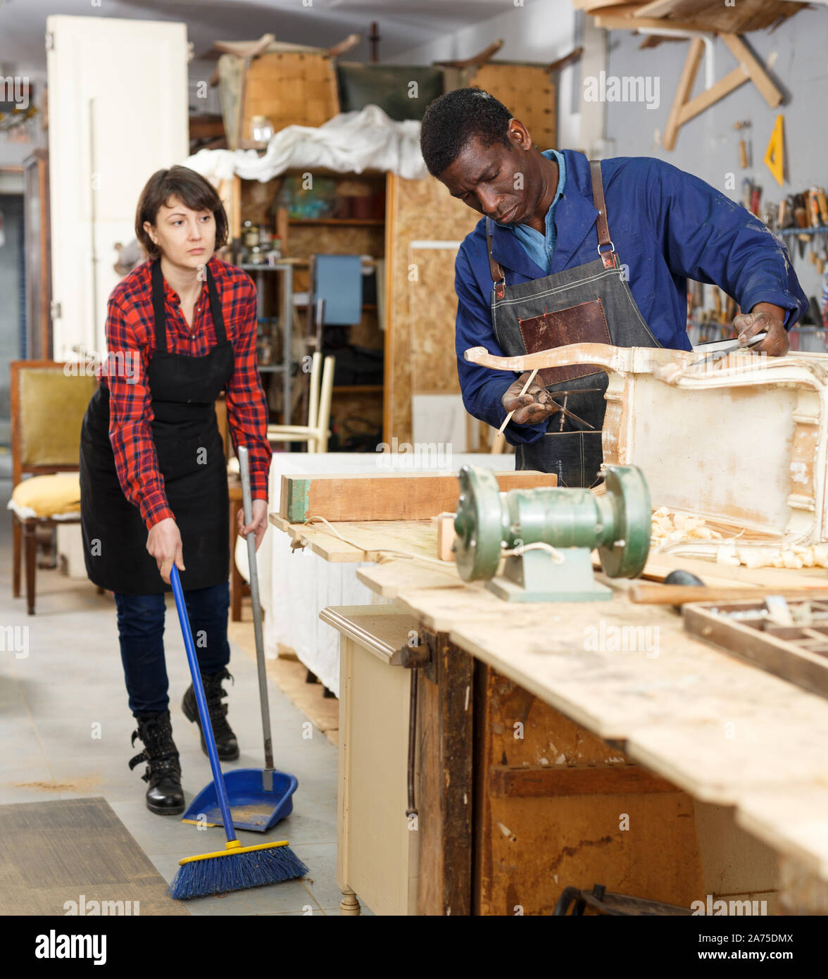 Portrait of male and female artisans in process of renewing vintage ...