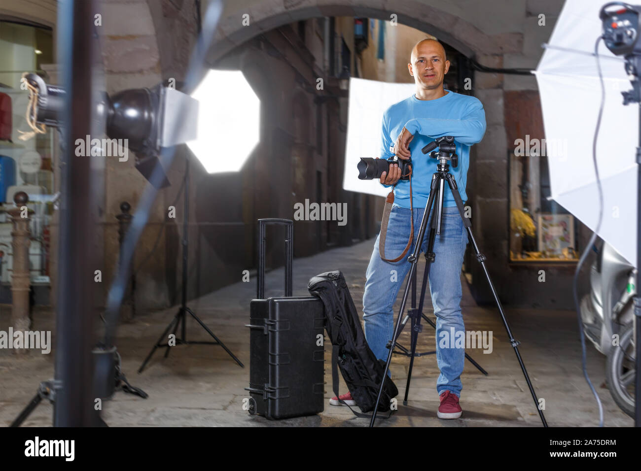 Portrait of smiling photographer with his camera during professional ...