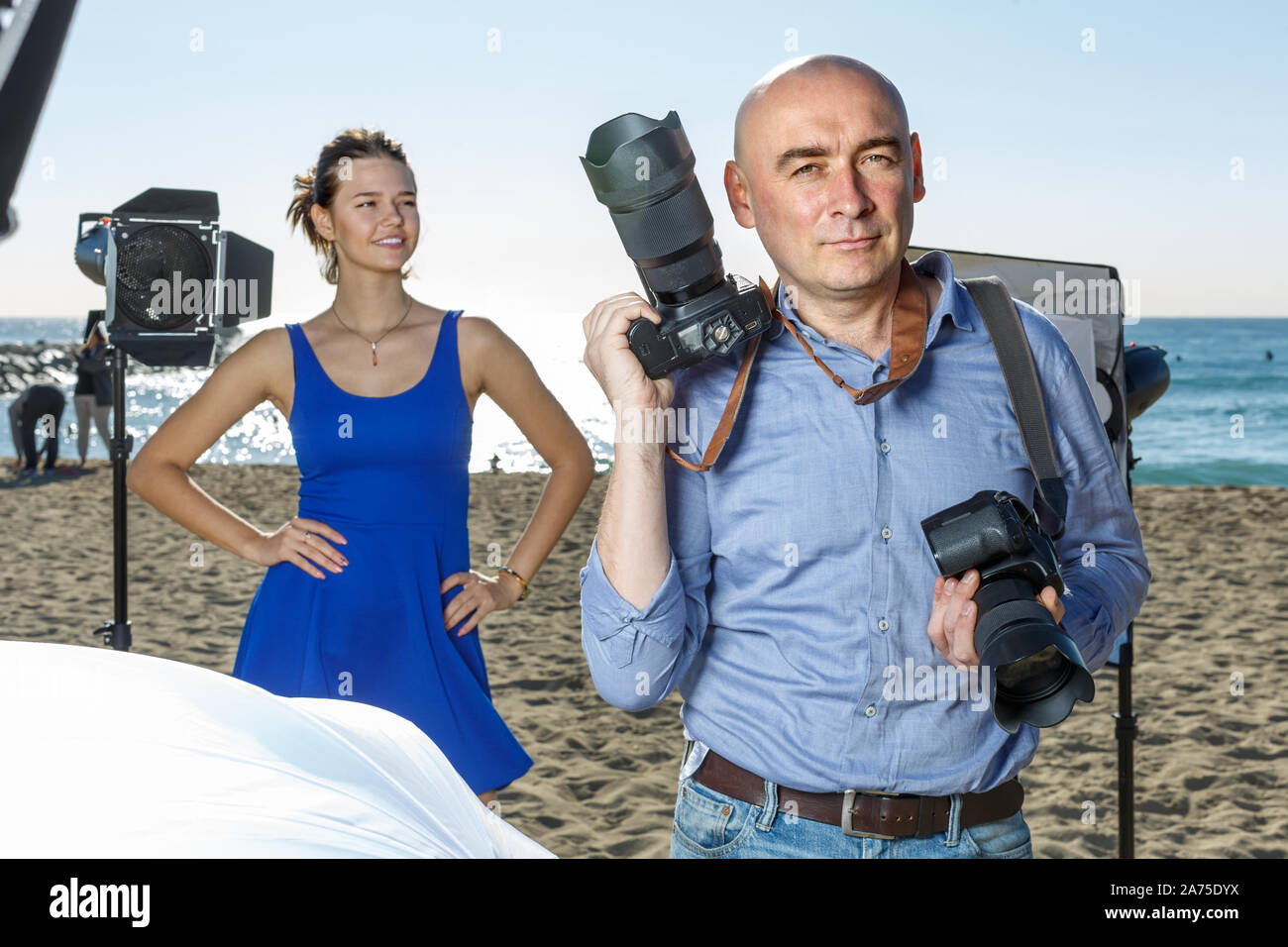 Portrait of successful photographer with his camera during professional ...