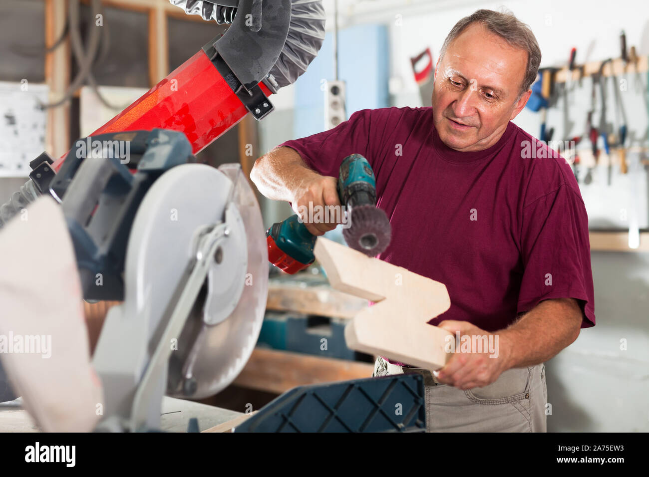 Worker grinds wooden 3d detail on grinding machine Stock Photo - Alamy