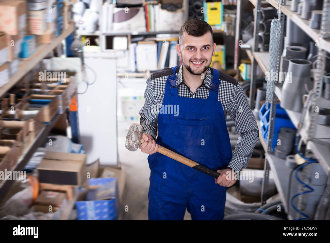Positive worker showing his working tools at workshop Stock Photo - Alamy