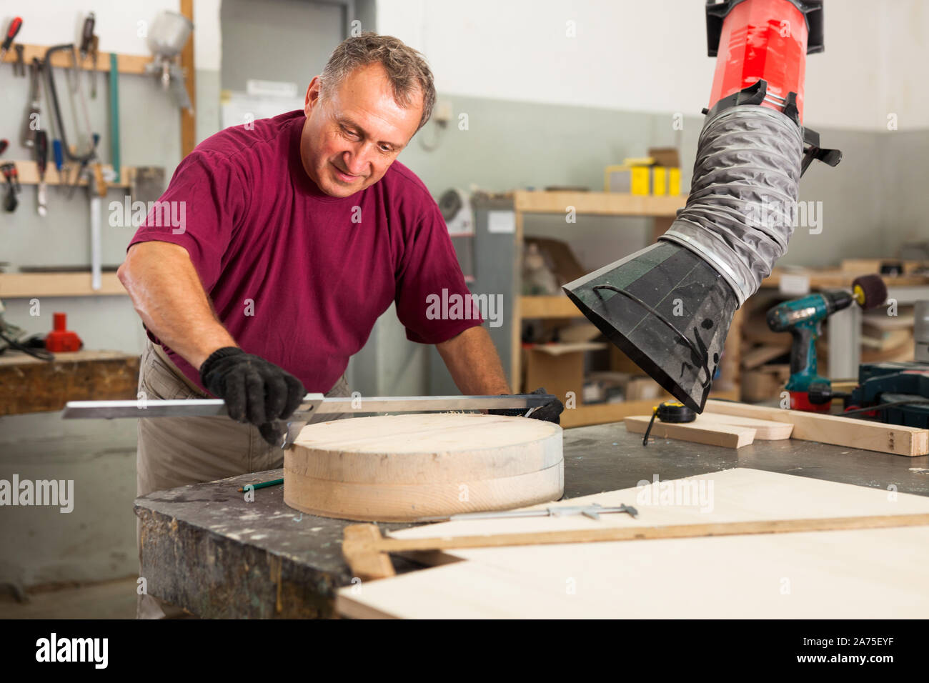 Worker performs measurements on wooden workpiece with caliper. Working ...