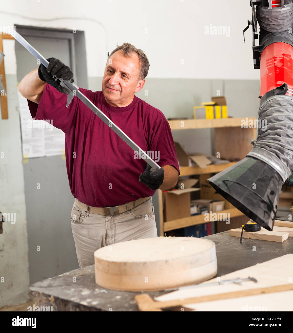 Worker performs measurements on wooden workpiece with caliper. Working ...