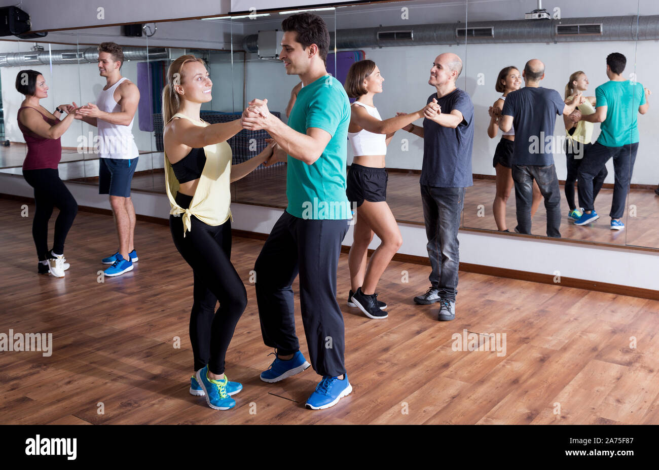 Group of smiling people dancing bachata together in dance hall Stock ...