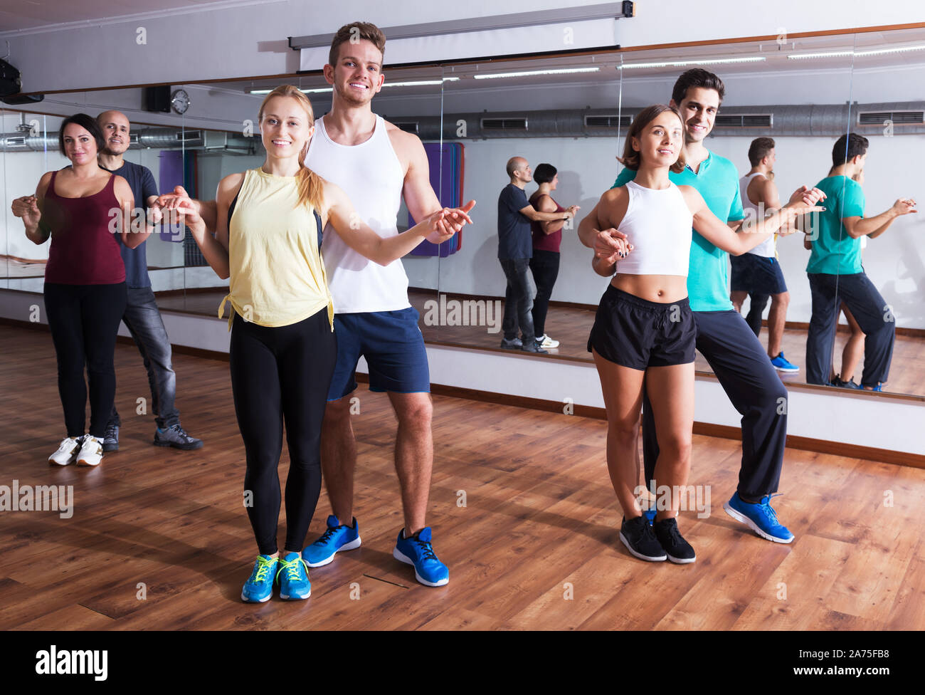 Cheerful dancing couples learning salsa at dance hall Stock Photo - Alamy