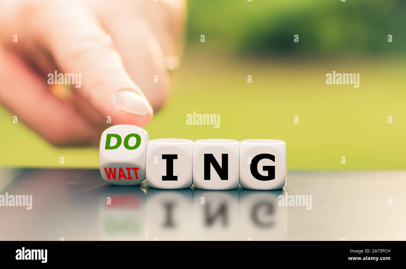 Hand turns a dice and changes the expression "waiting" to "doing Stock ...