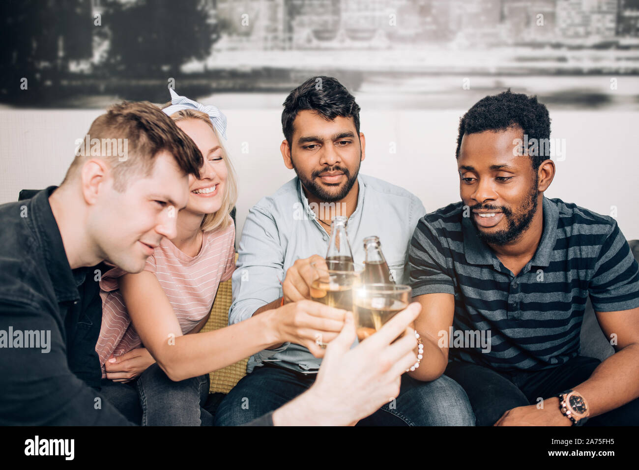 Four friends having small home party, celebrating meeting, sitting on ...