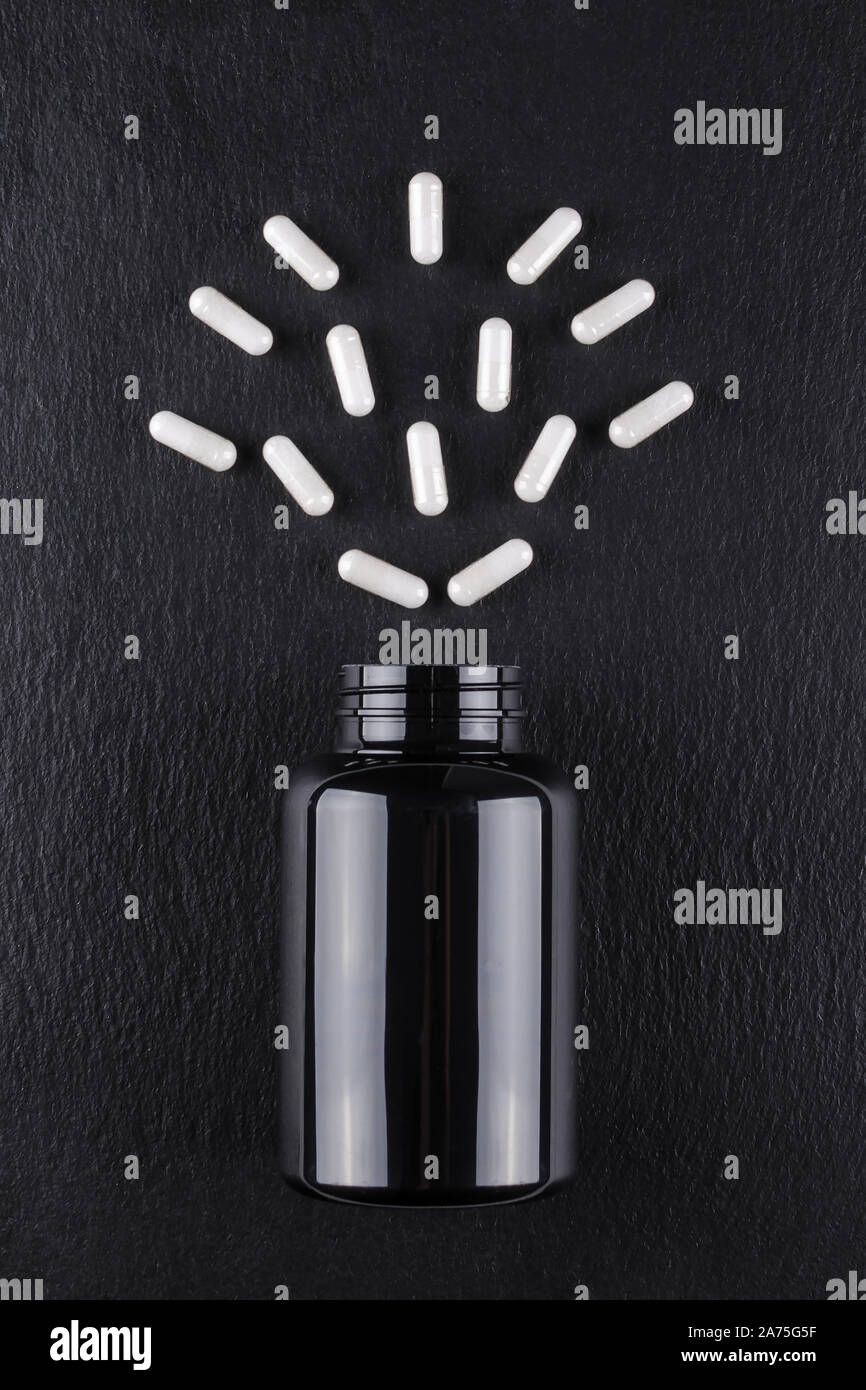 white capsules like a face on black background Stock Photo - Alamy