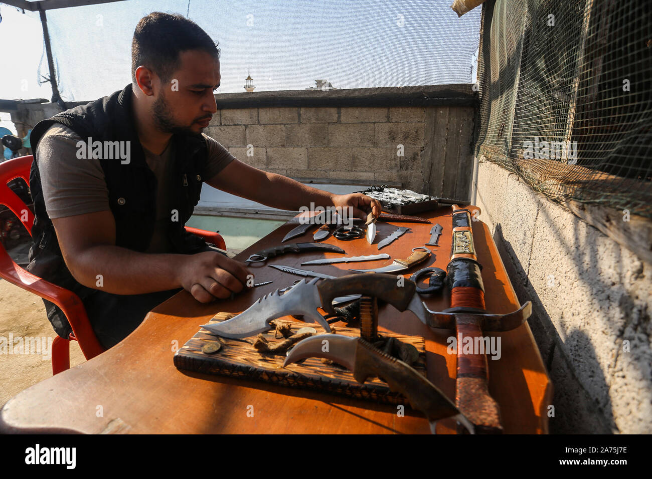 A Palestinian man Saif Abu Adra, makes daggers and swords in his small ...