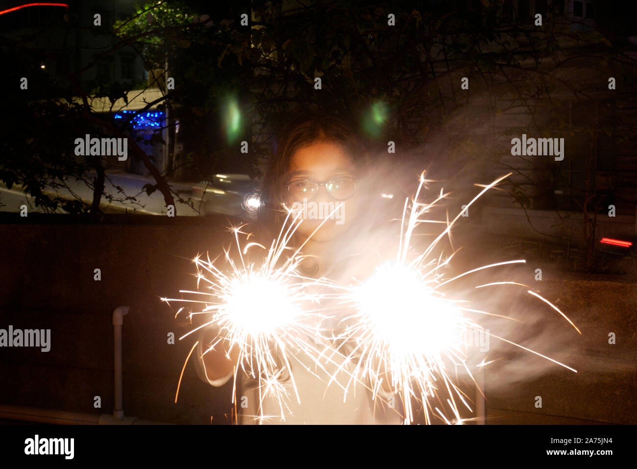 YOUNG WOMAN BURSTING FIRECRACKERS DURING DIWALI IN MUMBAI Stock Photo ...