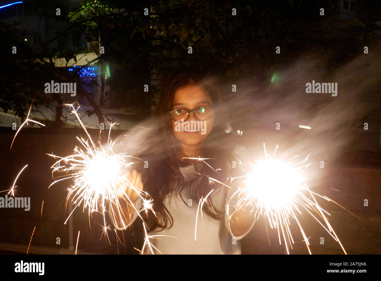 YOUNG WOMAN BURSTING FIRECRACKERS DURING DIWALI IN MUMBAI Stock Photo ...
