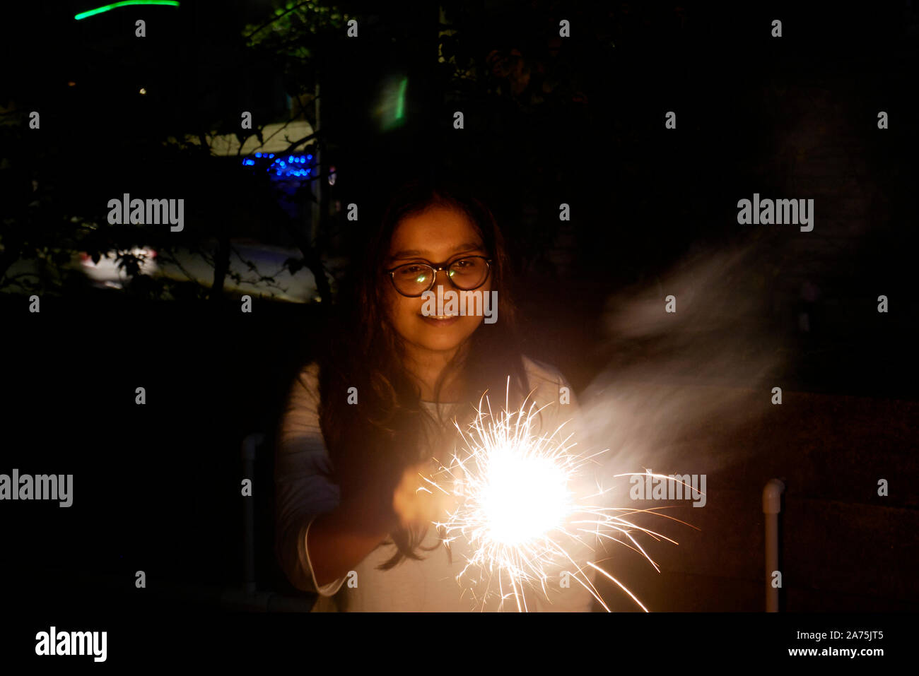 YOUNG WOMAN BURSTING FIRECRACKERS DURING DIWALI IN MUMBAI Stock Photo ...