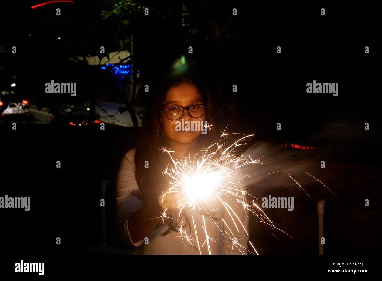 YOUNG WOMAN BURSTING FIRECRACKERS DURING DIWALI IN MUMBAI Stock Photo ...