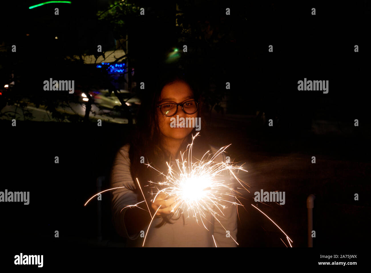 YOUNG WOMAN BURSTING FIRECRACKERS DURING DIWALI IN MUMBAI Stock Photo ...
