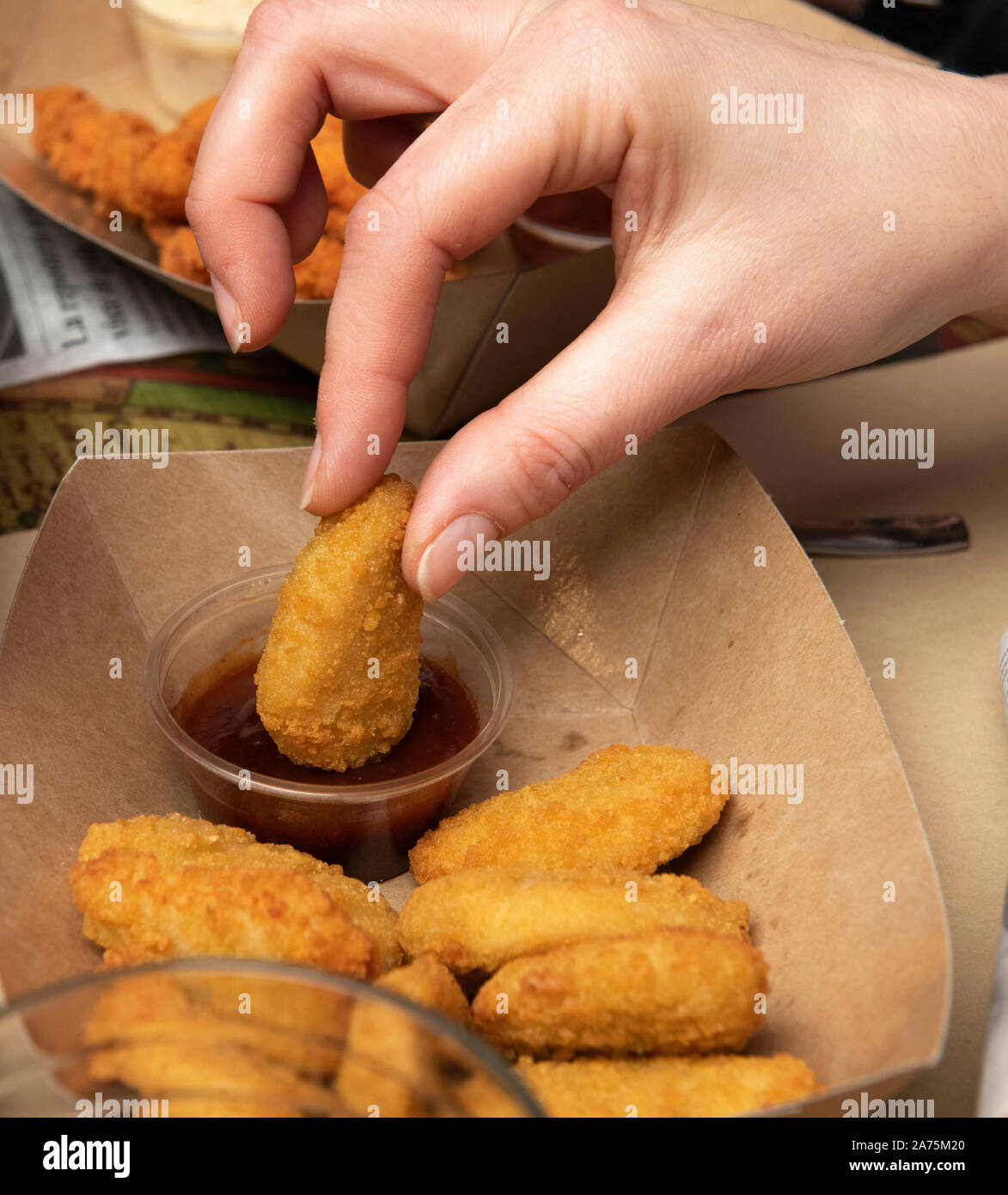 Woman eating chicken nuggets in a restaurant Stock Photo - Alamy