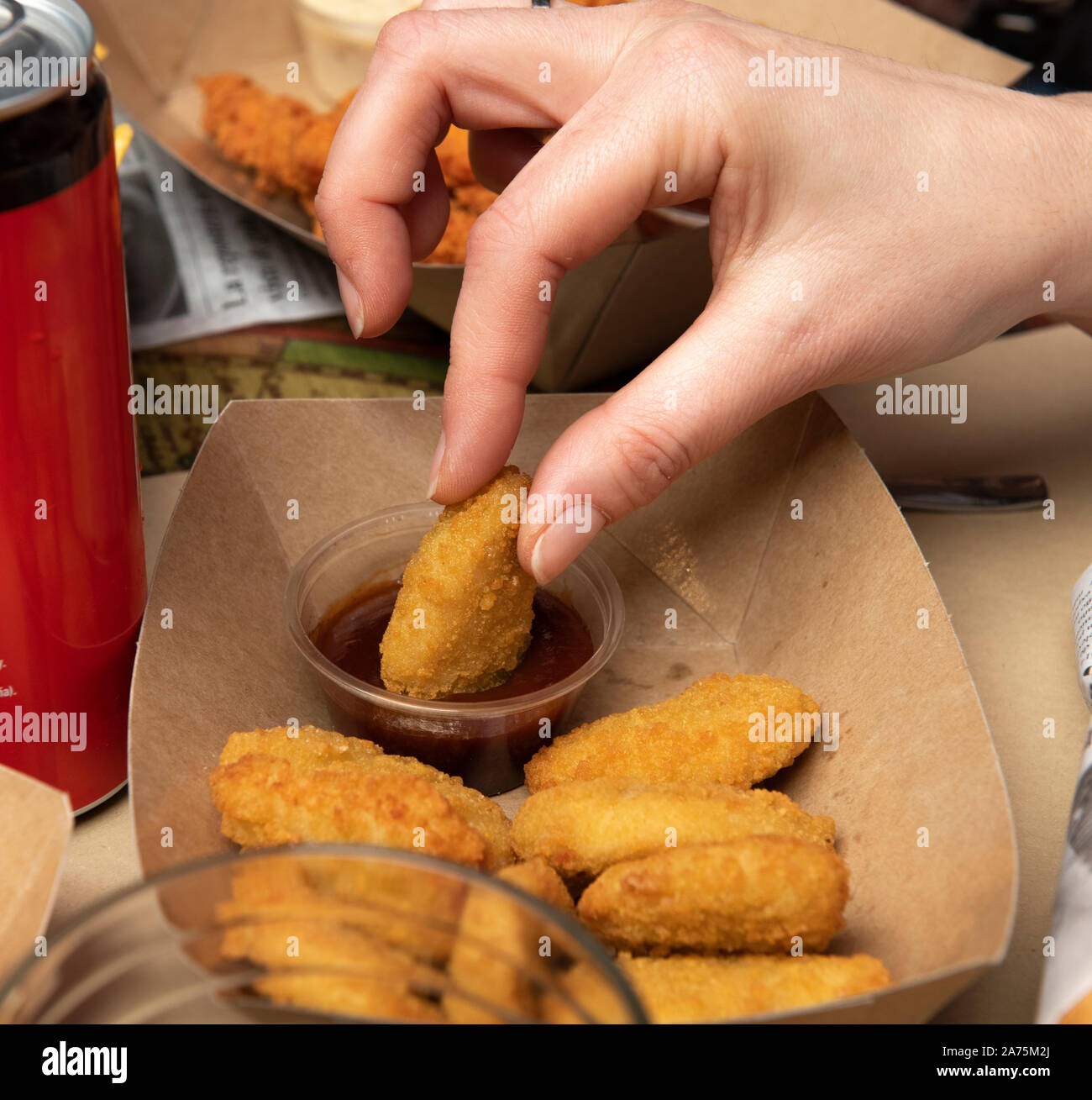 Woman eating chicken nuggets in a restaurant Stock Photo - Alamy