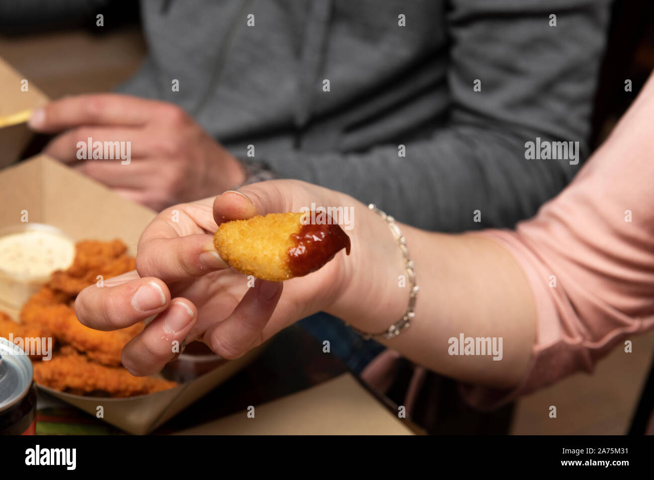 Woman eating chicken nuggets in a restaurant Stock Photo - Alamy