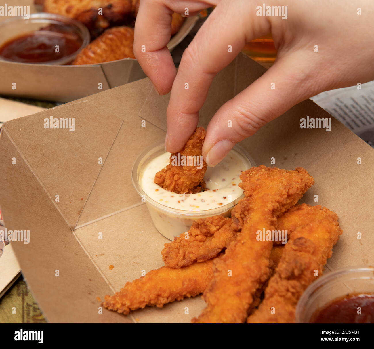 Woman eating breaded chicken in a restaurant Stock Photo - Alamy