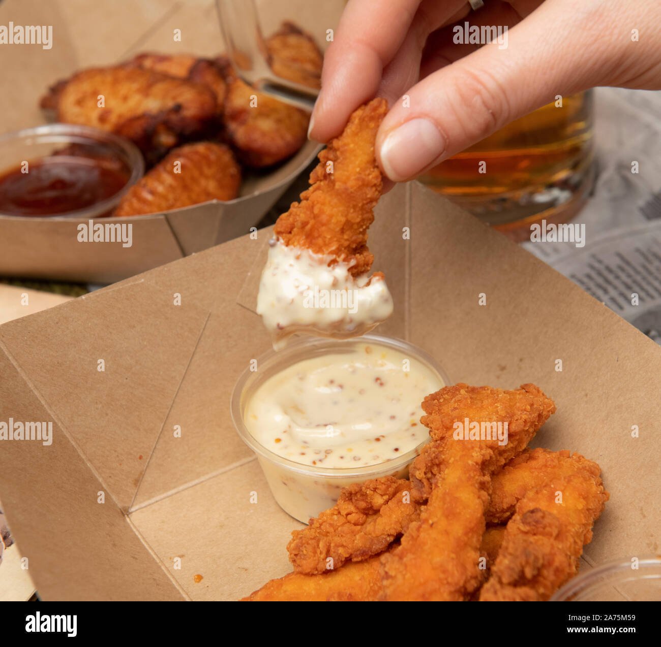 Woman eating breaded chicken in a restaurant Stock Photo - Alamy