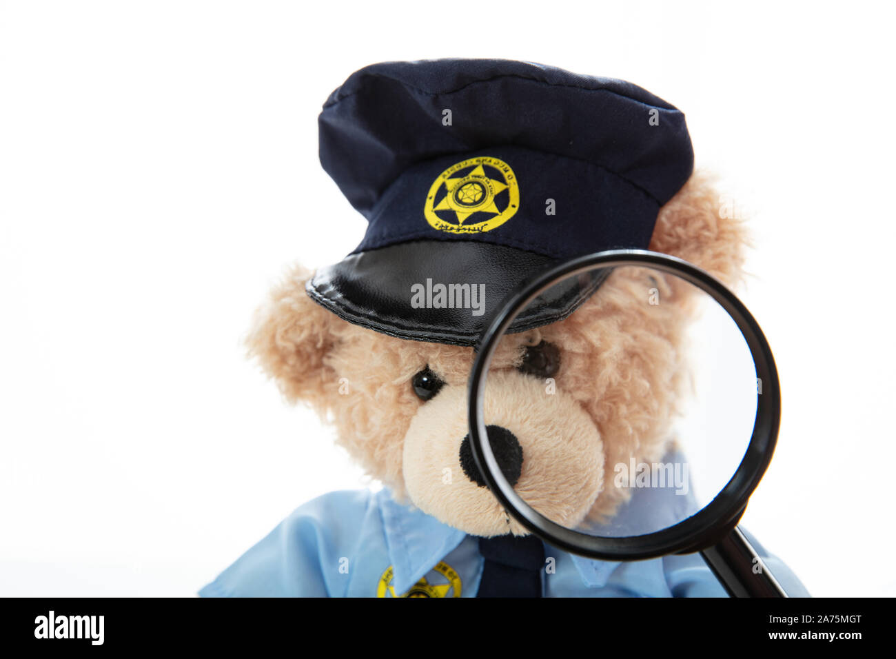 Police officer teddy bear in uniform and a magnifying glass isolated ...
