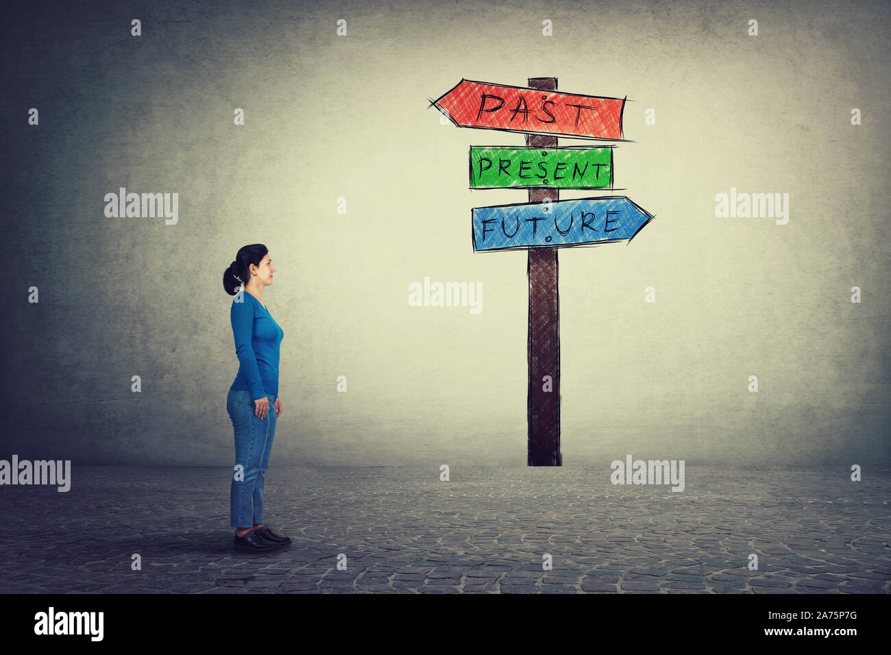Side view of young woman standing in front of a signpost with arrows ...