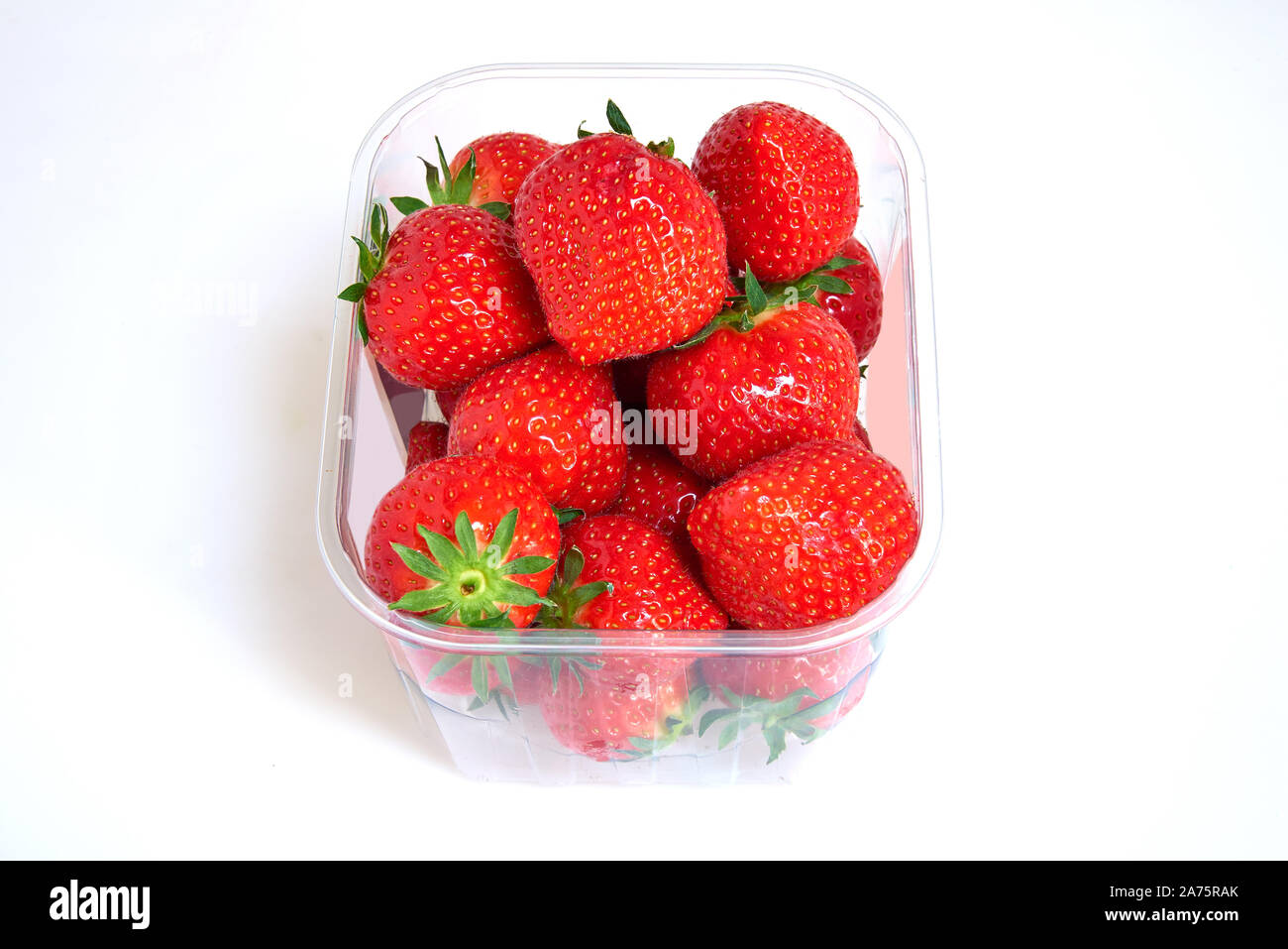 Plastic box of Strawberries on white Stock Photo - Alamy