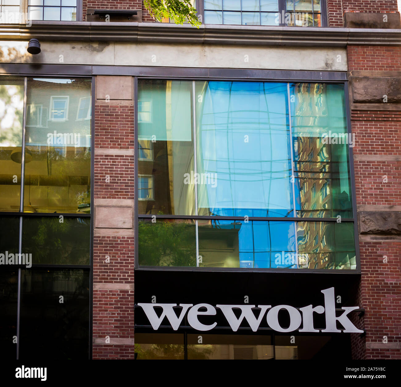 Signs announce the location of a WeWork co-working space location in ...