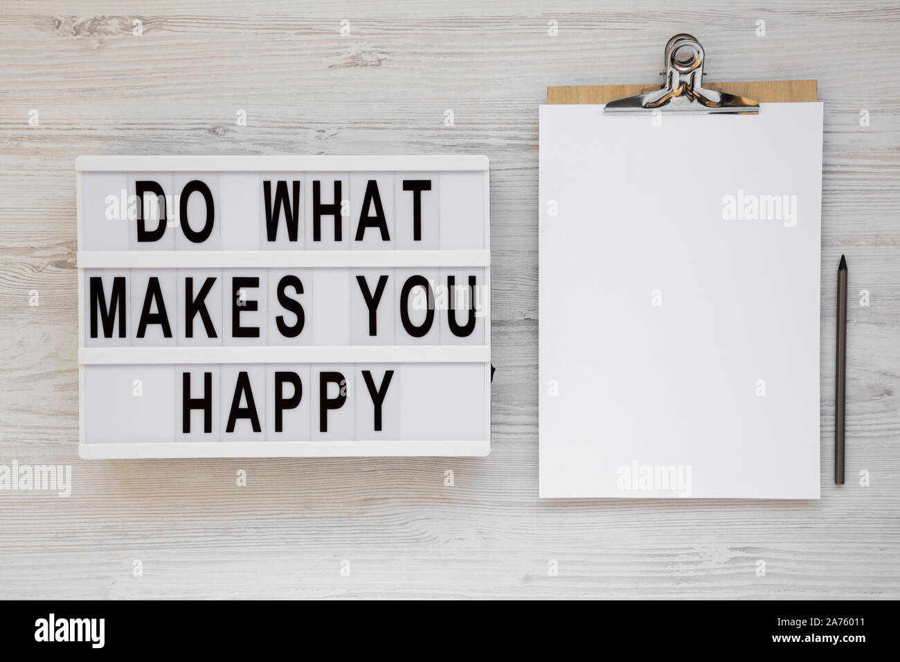 'Do what makes you happy' words on a modern board, clipboard with blank ...