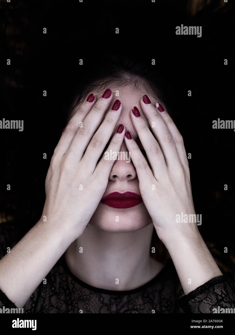 Beautiful young woman covering her face with hands Stock Photo - Alamy