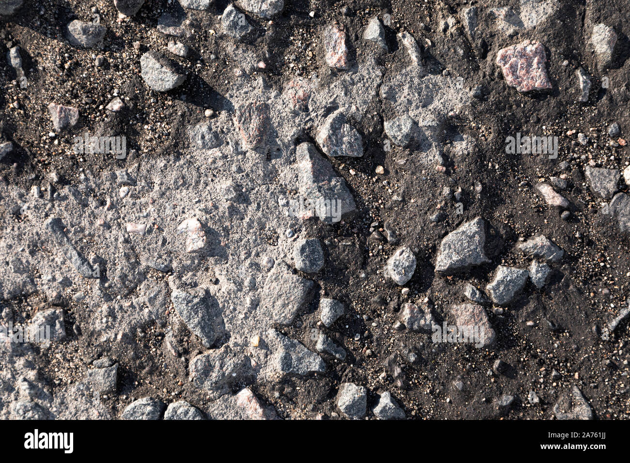 Closeup worn cracked asphalt driveway with gravel Stock Photo - Alamy