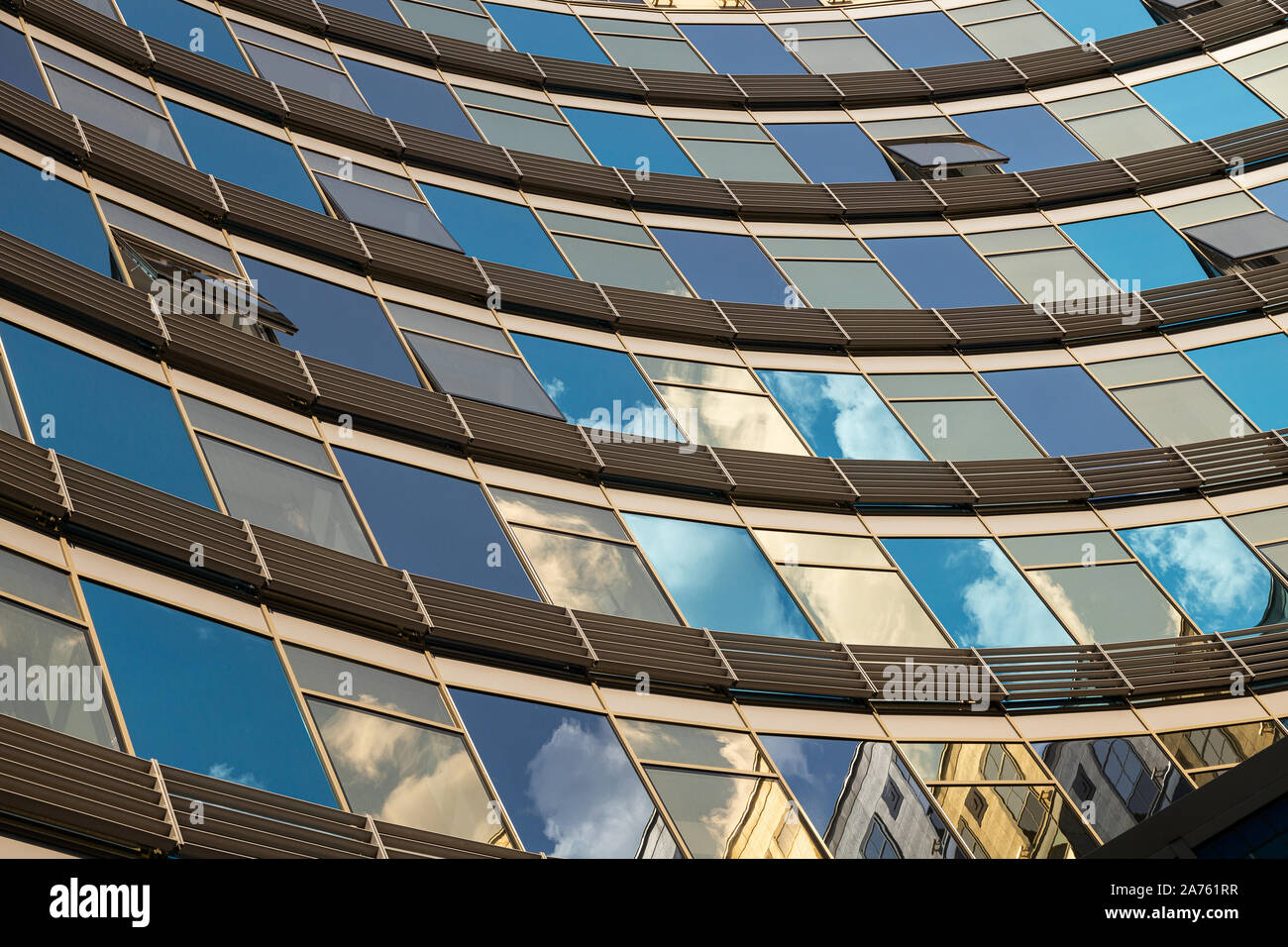 Closeup of glass wall of blue and golden shades with windows reflecting ...