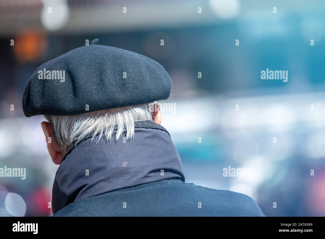 Back view of elderly male with typical french cape beret walking on ...