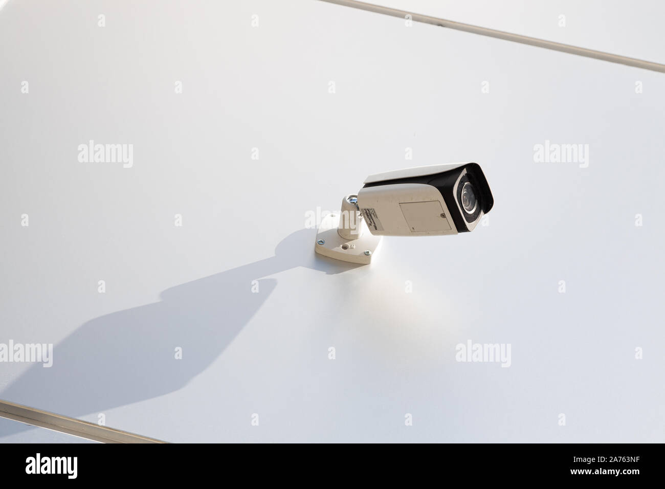 Bottom view of high-tech white video observation camera on smooth white ...