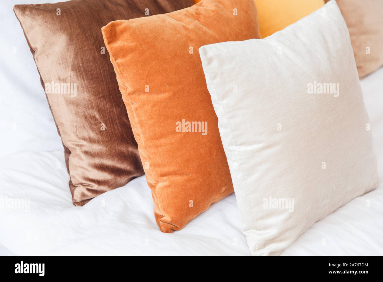 Colored velvet pillows on the bed. Elements of home comfort Stock Photo ...
