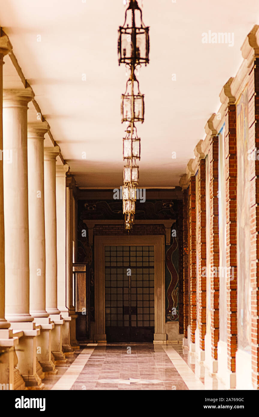 Architectural detail of a long exterior hall with columns and lights in ...