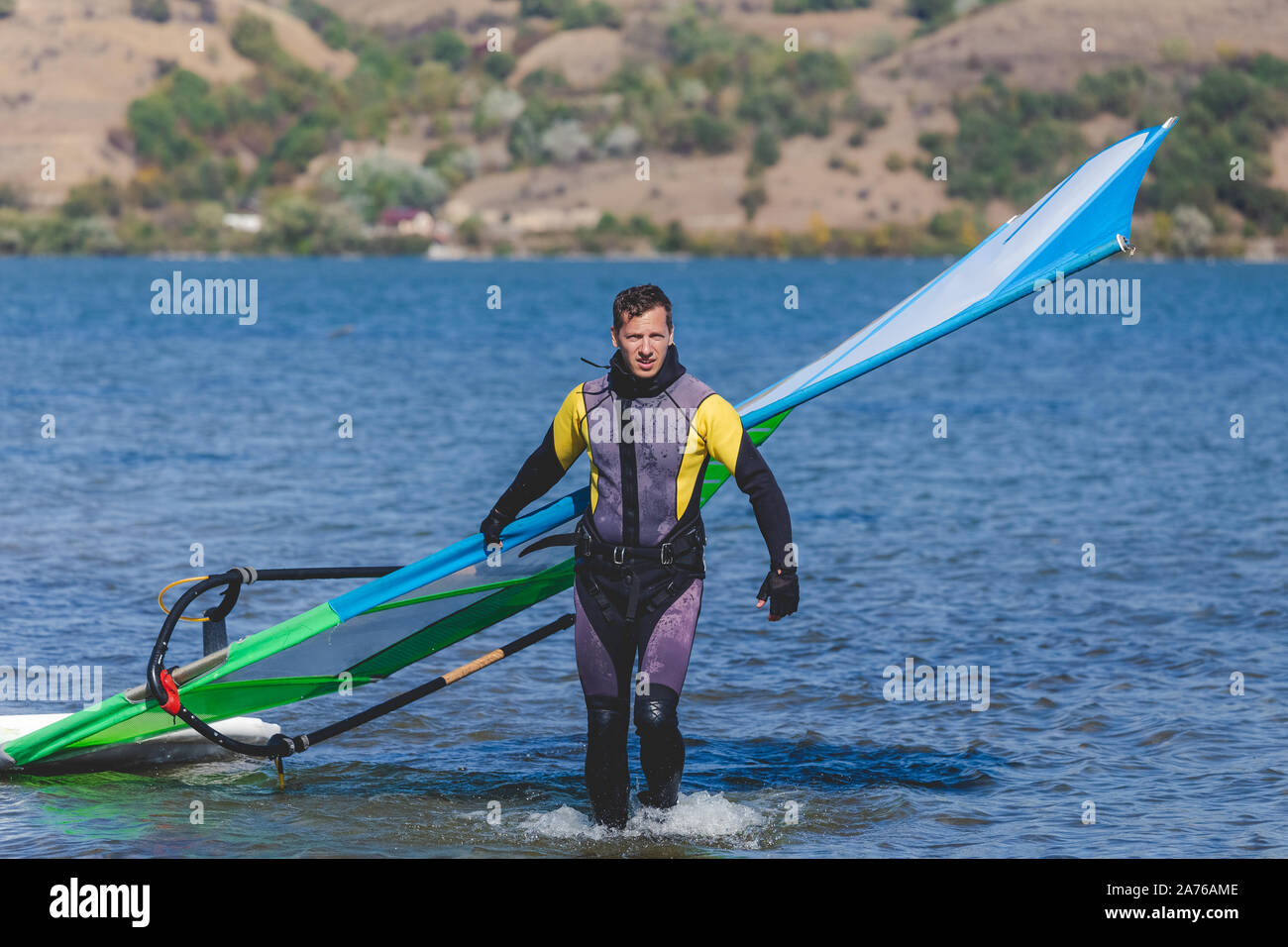 Windsurfer with surfing board and sail coming out from water Stock ...