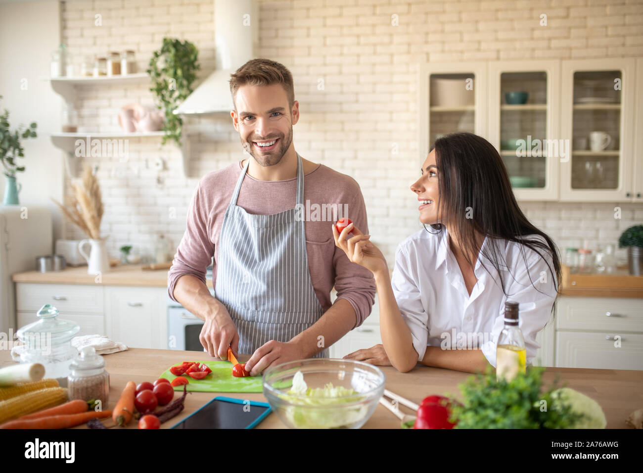 Husband feeling joyful while cooking for his woman Stock Photo - Alamy