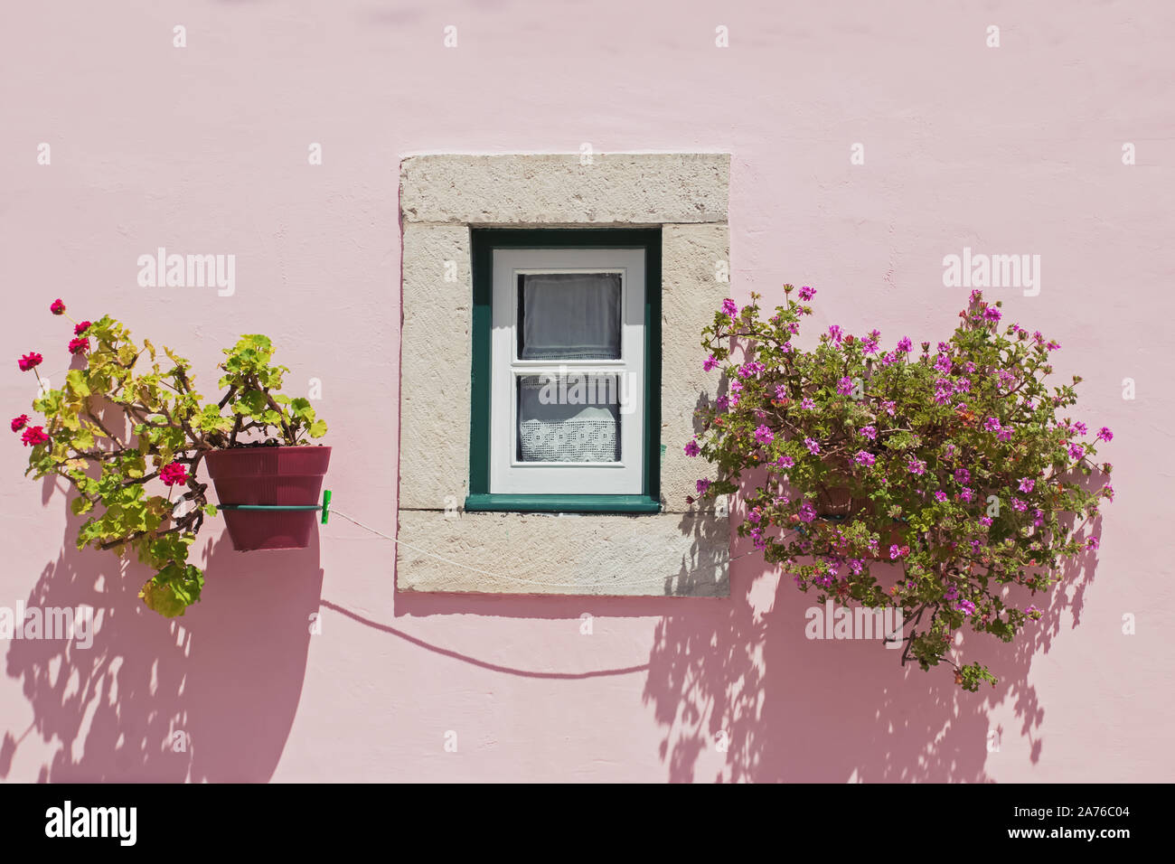 Small cute window with flowers on the pink wall facade Stock Photo - Alamy