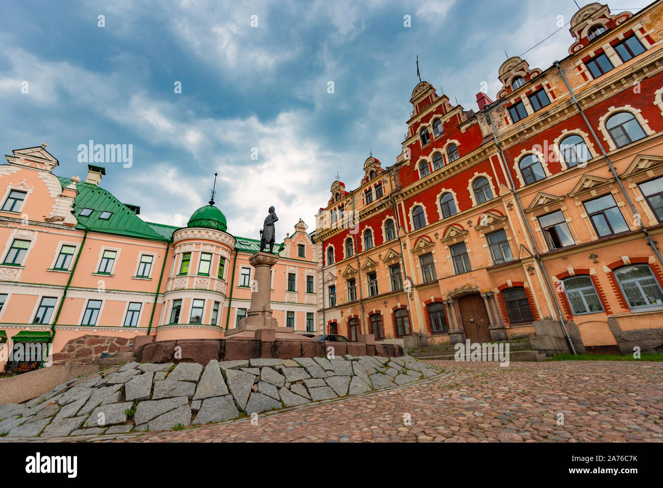 Old town hall of Vyborg city in Russia. Monument in foreground and blue ...