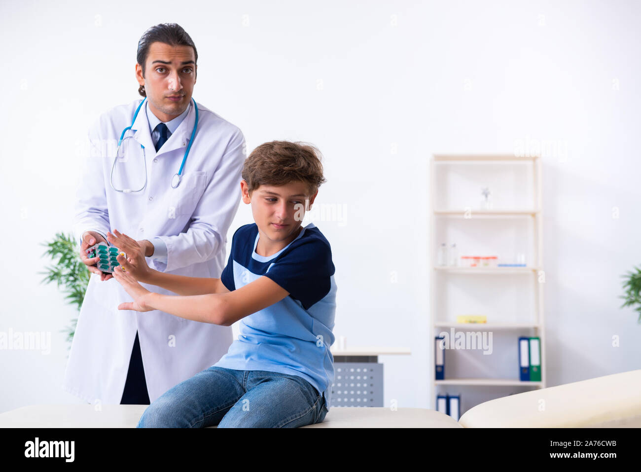 The young male doctor examining boy in the clinic Stock Photo - Alamy