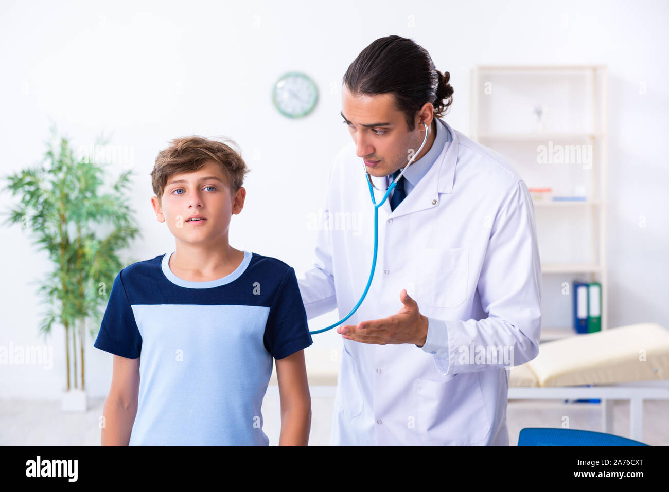 The young male doctor examining boy in the clinic Stock Photo - Alamy