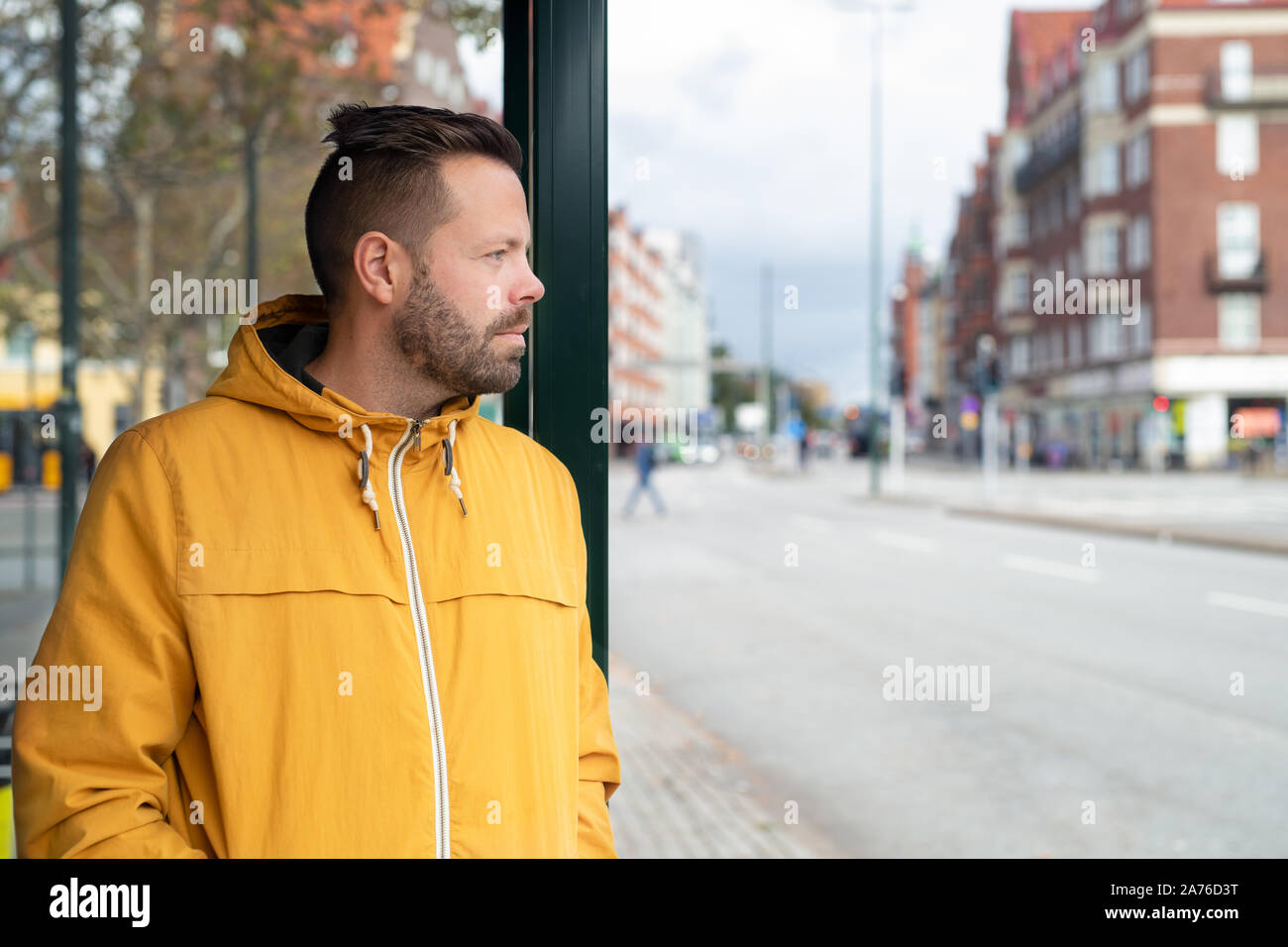 man waiting for bus at bus stop Stock Photo - Alamy