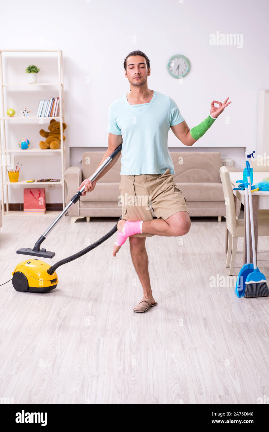 The young injured man cleaning the house Stock Photo - Alamy