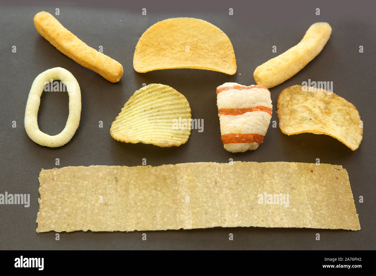 different kind of potato chips on a black background Stock Photo - Alamy