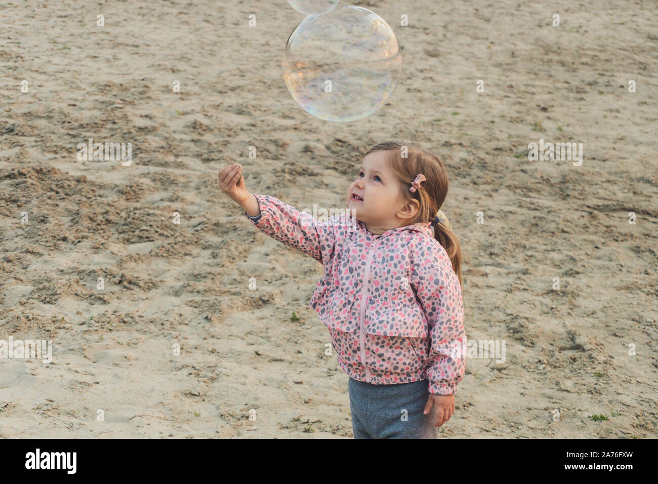 Child playing outside bubbles hi-res stock photography and images - Alamy